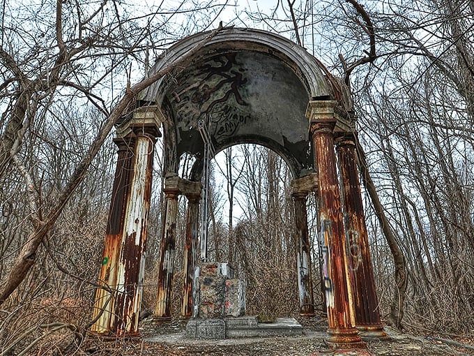 The haunting centerpiece of Hell House: a metal cross stands sentinel within weathered columns, like a scene from a gothic novel come to life.