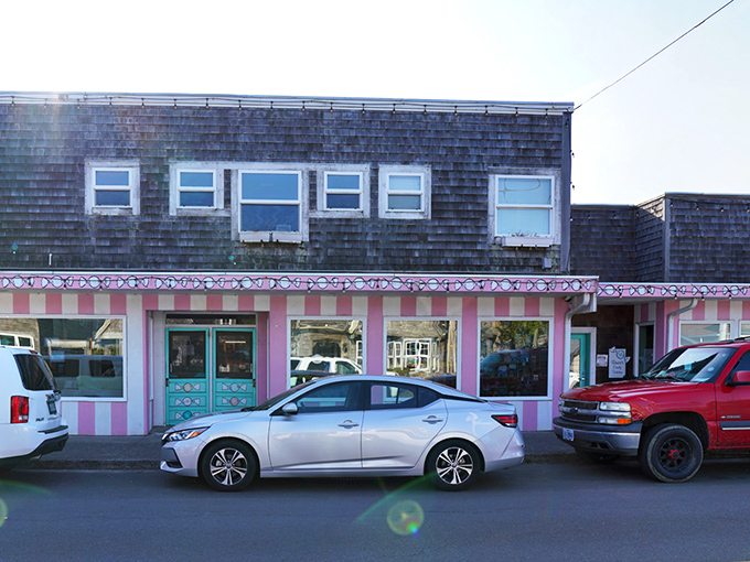 The pink and white striped façade of Bruce's Candy Kitchen stands out like a Wes Anderson film set come to life in Cannon Beach's coastal landscape.