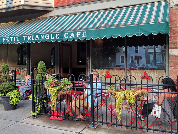 The emerald awning and red bistro chairs aren't just saying "Bonjour!"—they're practically singing La Marseillaise on this charming Cleveland corner.
