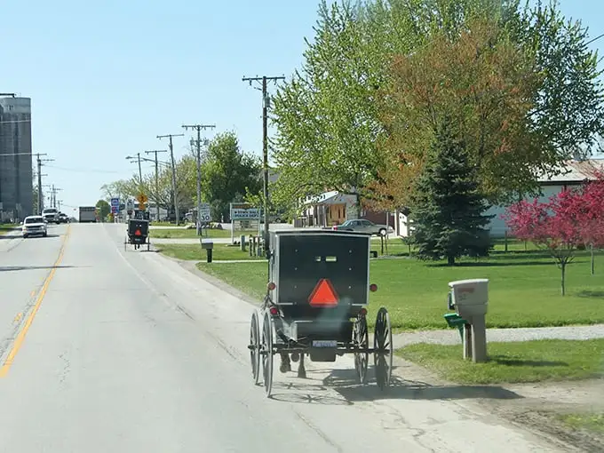 Where time travels at eight miles per hour. Amish buggies with their iconic orange safety triangles share the road with modern vehicles in Shipshewana.