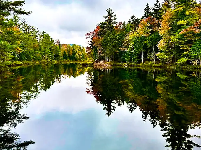 Mirror, mirror on the pond! Pillsbury's glassy waters create perfect reflections of autumn's fiery palette, nature's own Instagram filter at work.