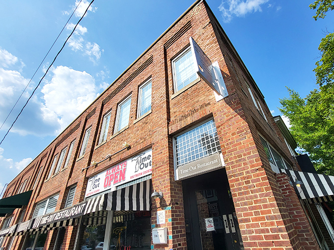 The brick facade of Time-Out beckons hungry visitors with its iconic striped awning and neon signs—a 24/7 beacon of Southern comfort on Franklin Street.