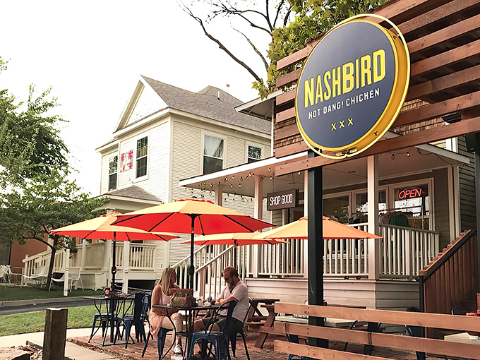 Nashbird's rustic wooden exterior isn't just Instagram-worthy—it's a siren call to chicken lovers everywhere. The circular yellow sign promises delicious things await.