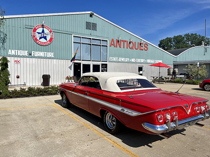 The mint-green exterior of Saugatuck Antique Pavilion stands proudly against a blue Michigan sky, with a classic convertible parked out front—nostalgia in architectural and automotive form.