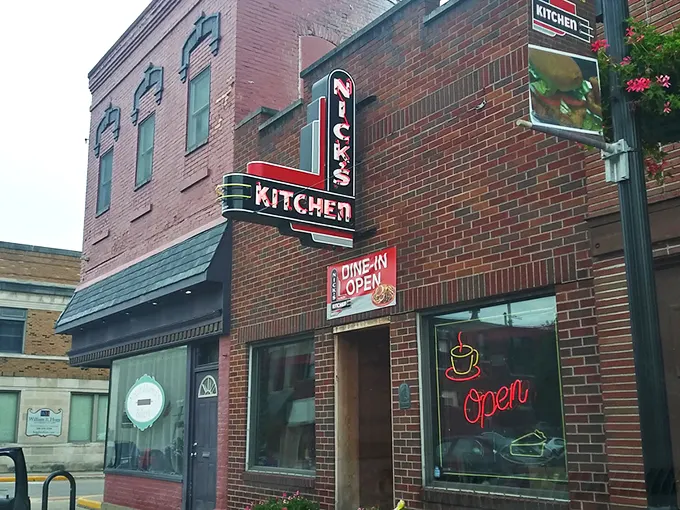The iconic neon sign of Nick's Kitchen beckons like a lighthouse for hungry travelers in downtown Huntington. Comfort food paradise awaits!