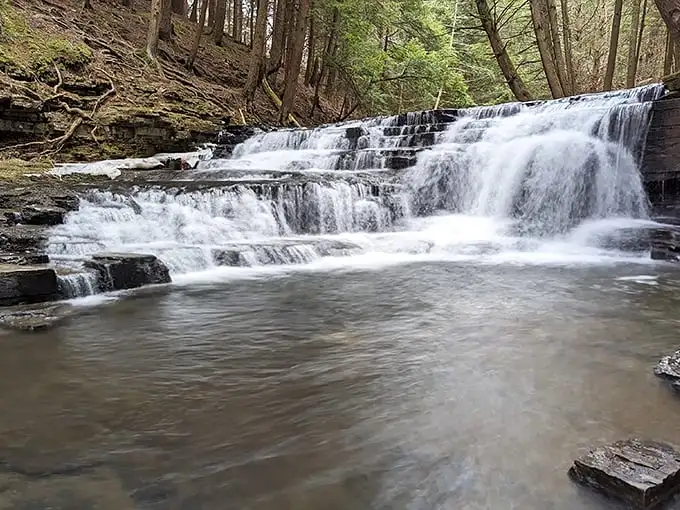 Nature's perfect waterfall tableau – where rushing water meets ancient rock in a dance that's been performing for millennia without ever taking a bow.