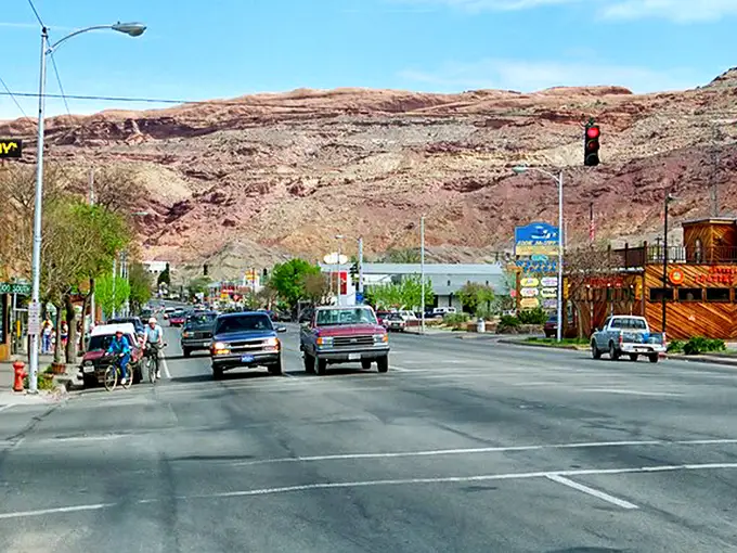 Main Street Moab, where pickup trucks are the fashion statement and those red rock backdrops aren't painted—Mother Nature just showing off.