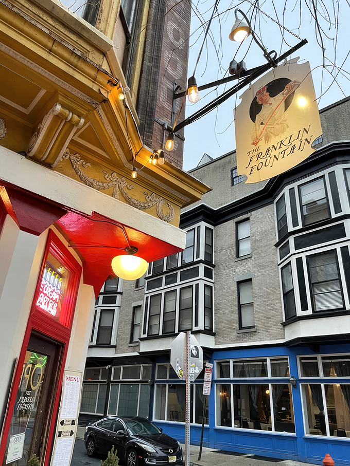 The storefront beckons like a time portal to ice cream's golden age—ornate yellow cornice, classic signage, and that brick facade promising sweet nostalgia inside.