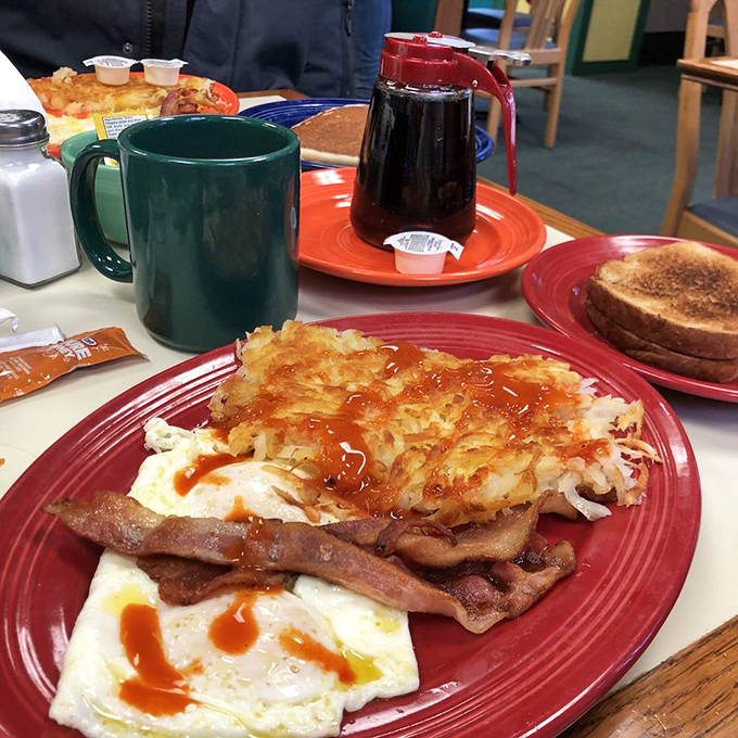 The breakfast platter that launched a thousand productive days—eggs, hash browns, bacon, and hot sauce in perfect harmony.