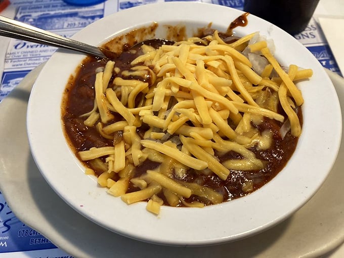 A bowl of chili crowned with a blizzard of melted cheese—winter comfort that warms you from the inside like a culinary hug.