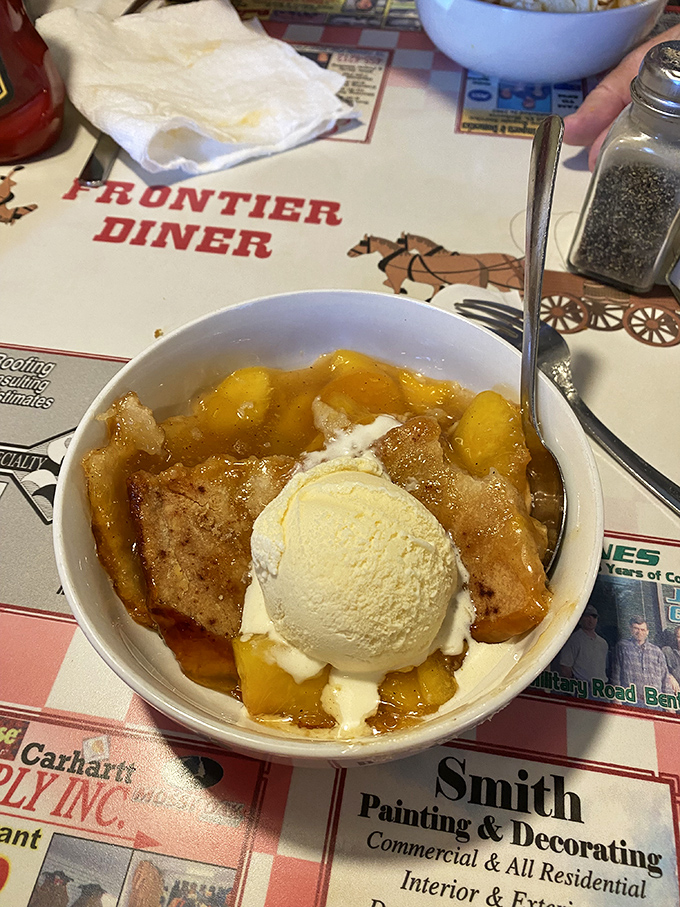Peach cobbler that doesn't just satisfy your sweet tooth—it throws a party for it. That scoop of vanilla ice cream melting into warm fruit is pure edible poetry.