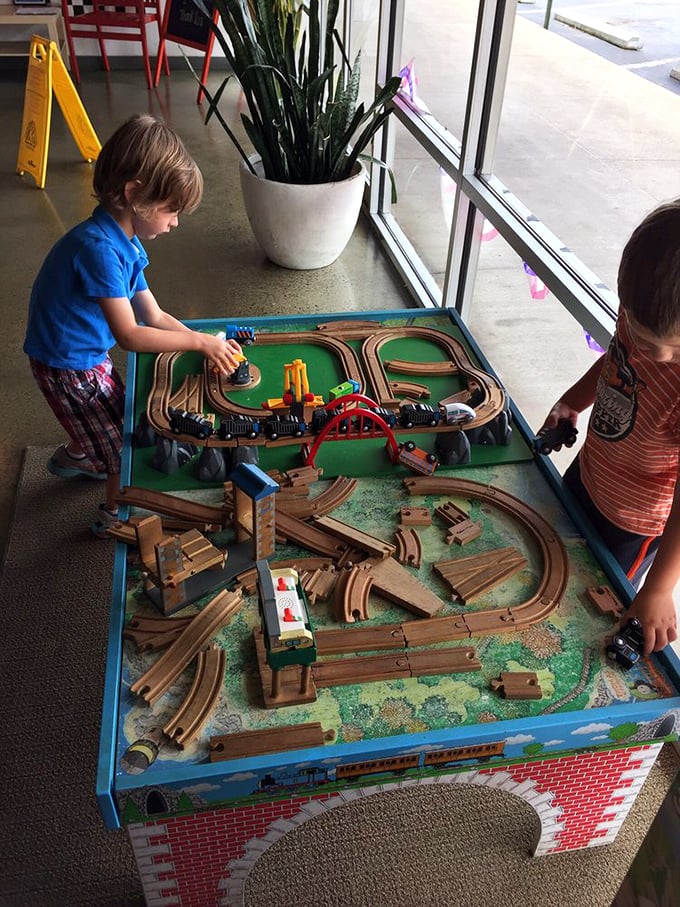 The train table—where future engineers and food critics alike can play while parents enjoy a moment of peace and an actual hot meal.