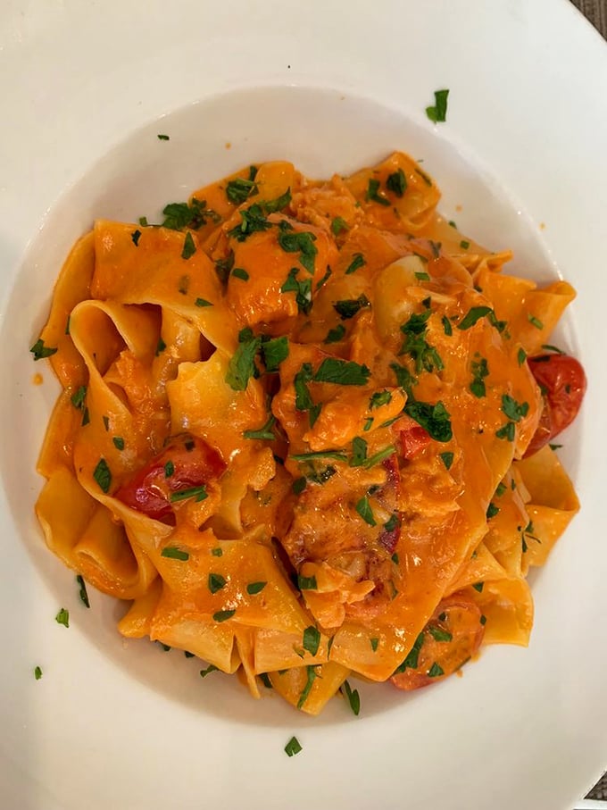 This lobster pasta is wearing a vibrant orange sauce like it's dressed for a night out. Those fresh herbs are the perfect accessories.