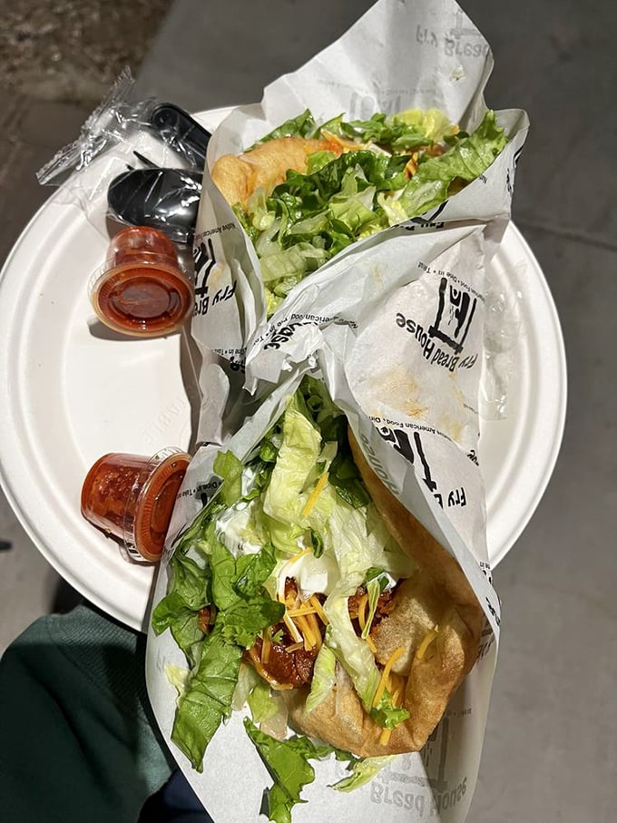 Al fresco dining with fry bread tacos. Fresh lettuce, seasoned meat, and that signature golden bread—proof that the best meals sometimes come on paper plates.