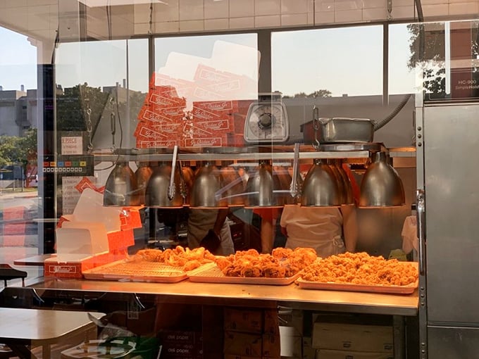 Behind the glass, culinary magic happens as fresh chicken transforms into the golden treasures that keep Kansas City coming back.