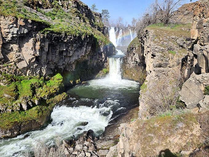 The falls don't just drop—they perform, cascading in stages like a well-choreographed aquatic dance down ancient stone.