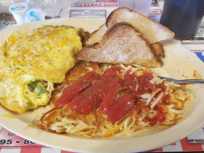 This omelet and those hash browns have clearly entered into a pact to make your morning spectacular. The ketchup is just there to witness the magic. 