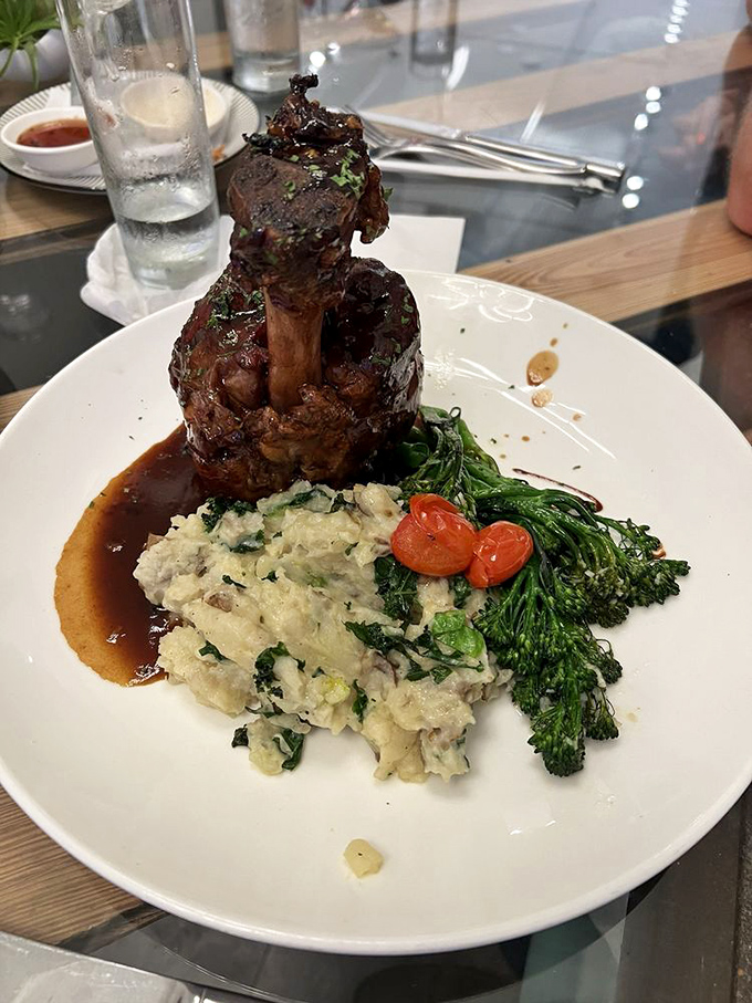 This pork shank doesn't just fall off the bone—it leaps with joy onto your fork, accompanied by mashed potatoes that could make a Frenchman weep.