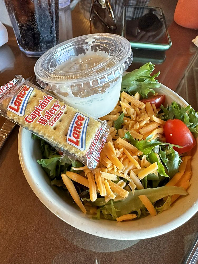 Even the side salad gets special attention here, with fresh greens, shredded cheese, and those Lance crackers that transport you straight back to childhood.