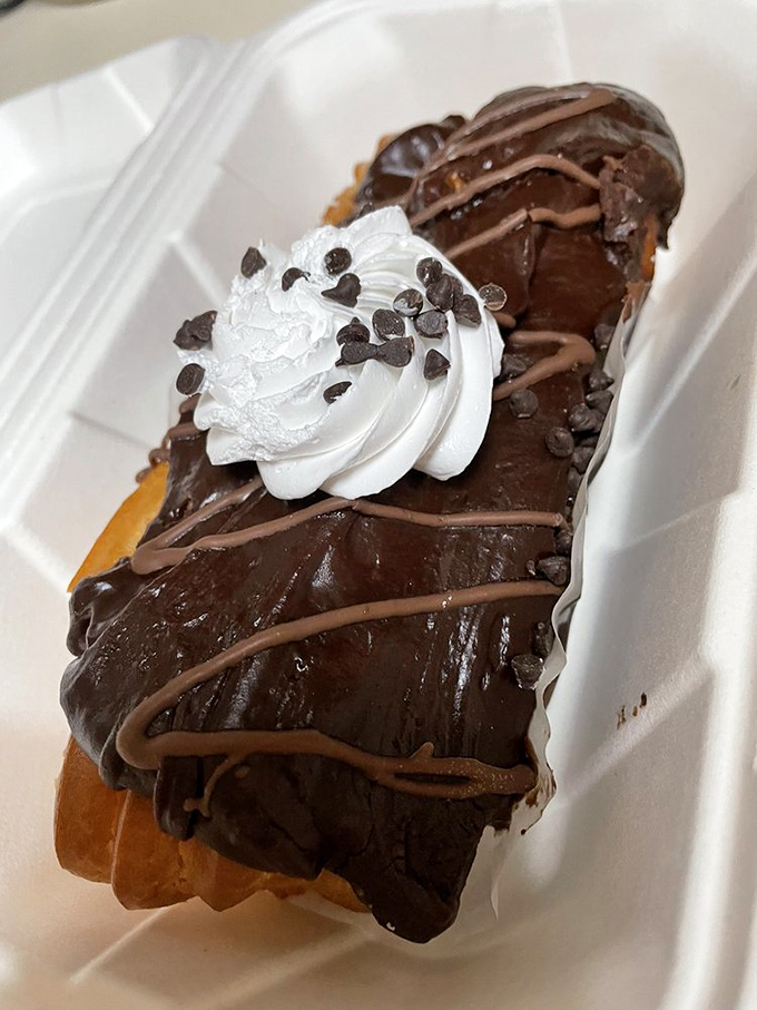 This éclair isn't just dessert—it's therapy with chocolate frosting. The whipped cream dollop is the chef's way of saying "You deserve this."