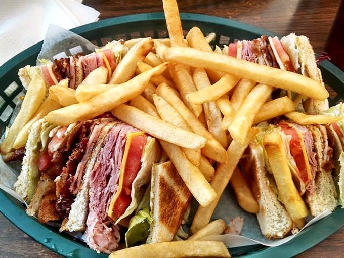 The club sandwich—architecture you can eat. Skyscraper of meat, supported by toothpick columns, surrounded by a golden french fry foundation.