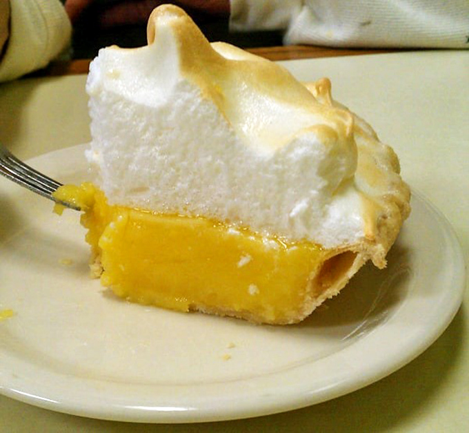 Lemon meringue pie with peaks so high they need their own elevation warning—sunshine on a plate.