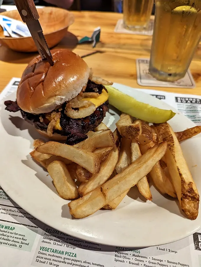 This isn't just a burger—it's architecture with cheese. The pickle stands guard like it knows something special is happening.