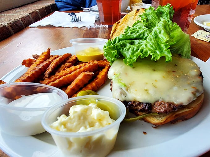 This isn't just a cheeseburger—it's architecture. The melted cheese cascades down the sides like a dairy waterfall, while sweet potato fries stand at attention.