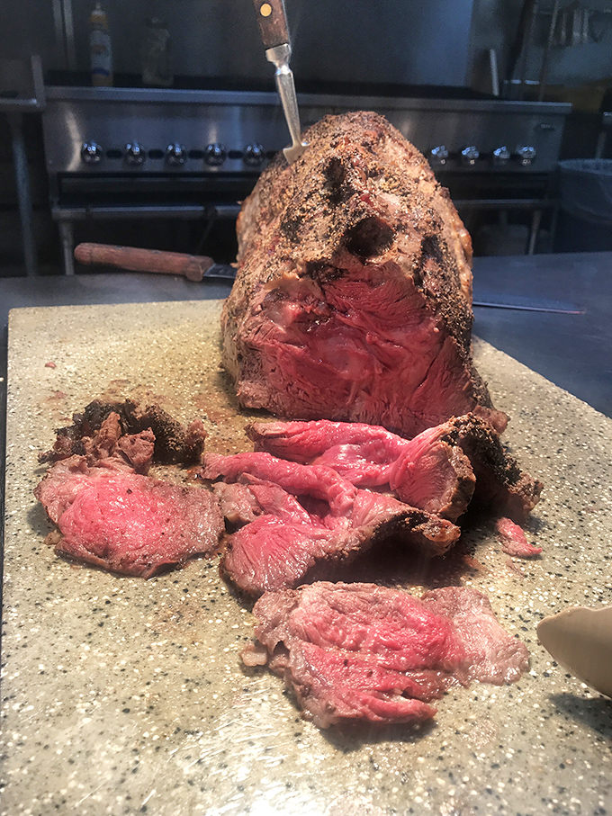 The prime rib in its natural habitat—gloriously rare and waiting for its close-up. Meat that makes vegetarians question their life choices.