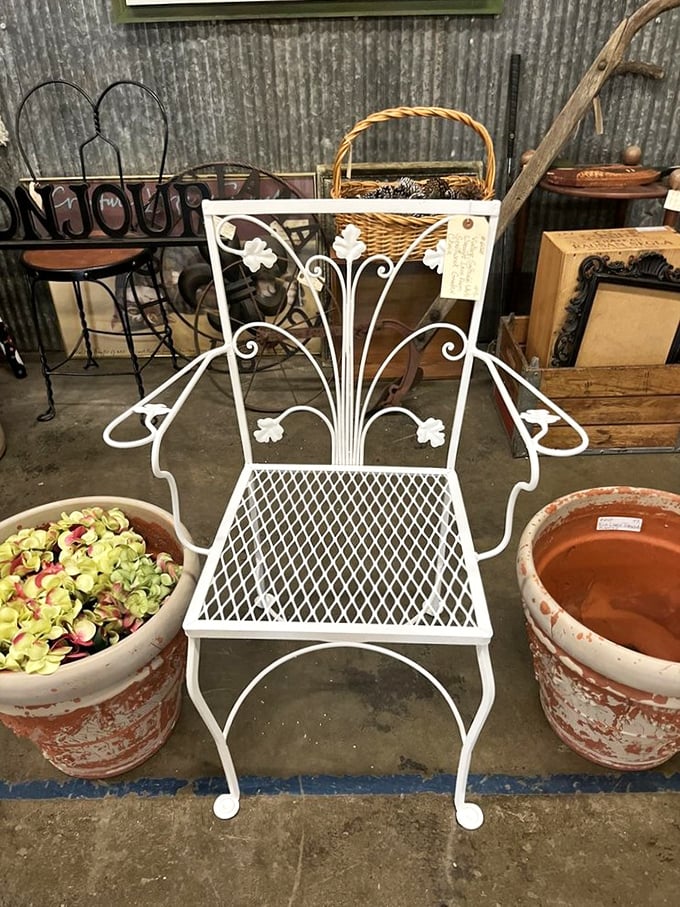 Garden furniture that refuses to go out of style—this white wrought iron chair awaits someone with enough sense to rescue it.