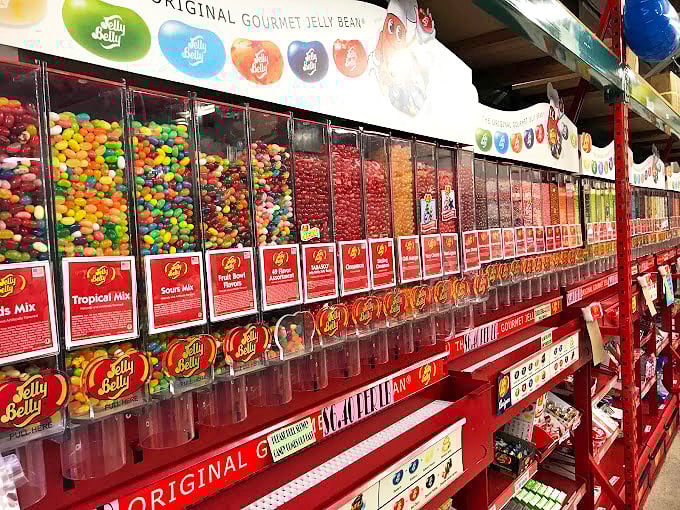 Jelly Belly dispensers stand like colorful sentinels, guarding flavors from the mundane to the magnificently bizarre.
