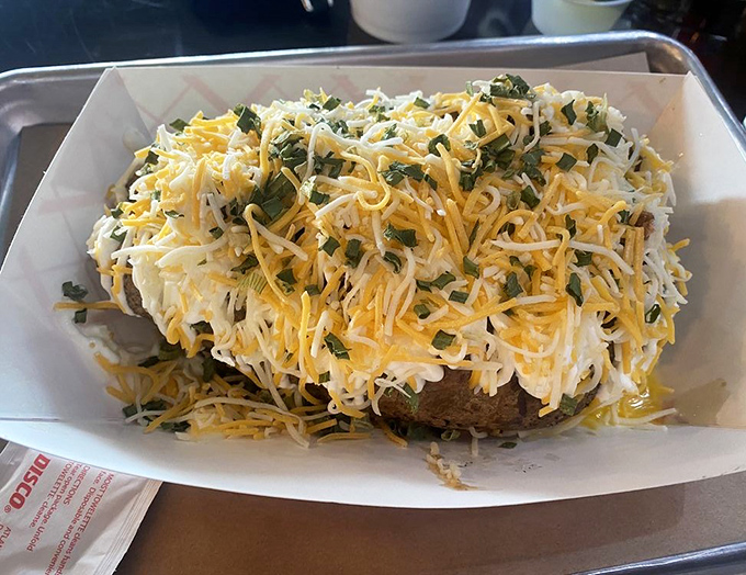 A loaded baked potato that's practically wearing a cheese sweater. This spud didn't just get dressed – it got completely decked out.