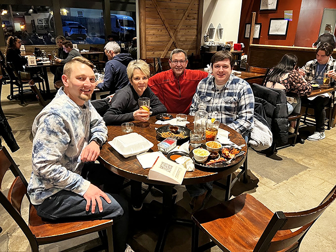 Happy diners experiencing the communal joy of barbecue—the table transformed into a smoke-infused United Nations of deliciousness.