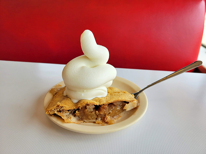 This isn't just apple pie – it's the final chapter in a love letter to American comfort food, topped with a cloud of whipped cream.