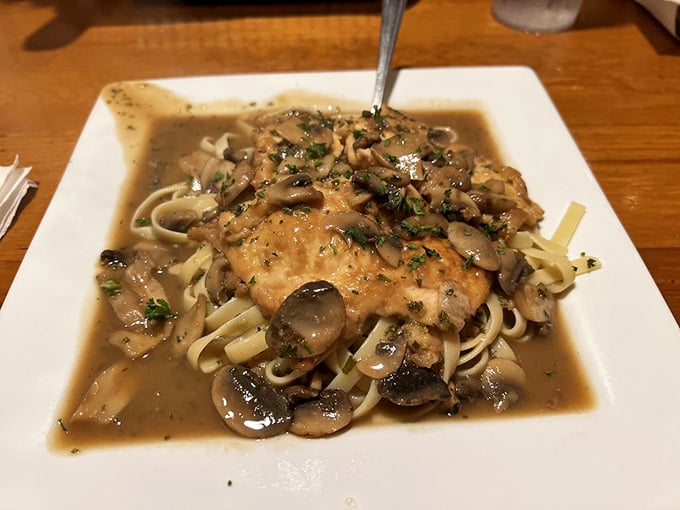 Chicken Marsala swimming in mushroom wine sauce—proof that sometimes the best vacation for your taste buds is just a short drive away.