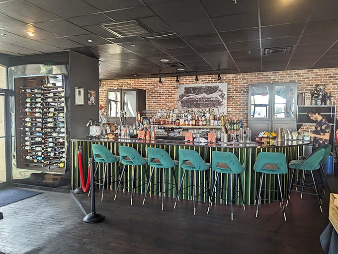 The bar beckons with turquoise chairs and bottles standing at attention—like a well-orchestrated prelude to an evening of culinary adventure.