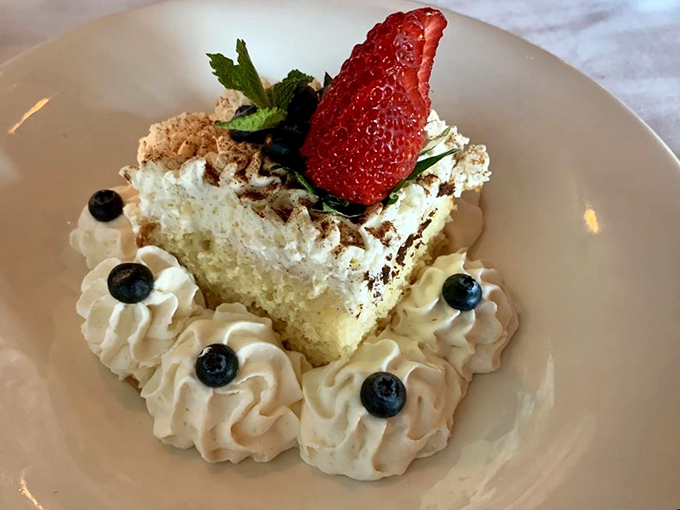Dessert that makes you reconsider saving room. That strawberry stands proudly atop its whipped cream kingdom like a sweet sentinel guarding the path to happiness.
