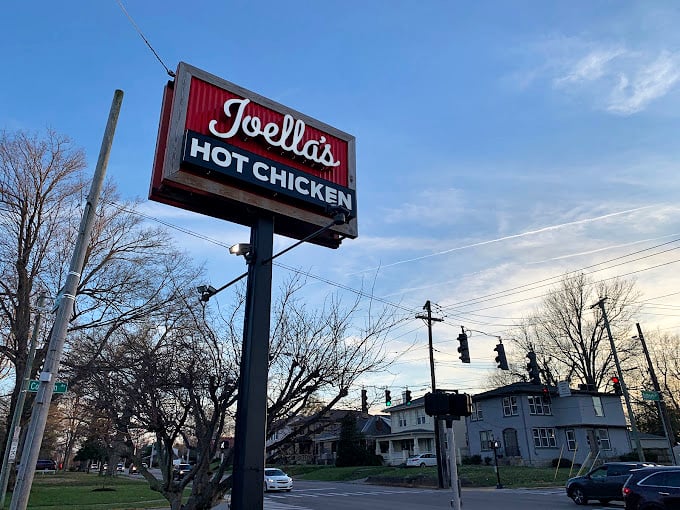 That sign isn't just announcing a restaurant—it's marking the spot where ordinary chicken goes to get its PhD in flavor, standing tall above Lexington's streetscape.