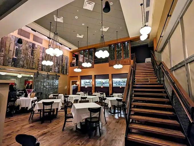 Soaring ceilings, elegant staircases, and cloud-like pendant lights create an atmosphere that says "yes, you're treating yourself tonight" without a hint of stuffiness.