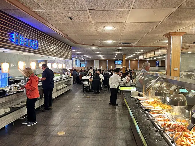 Hungry patrons navigate the buffet with the strategic precision of NASA engineers. That blue "Hibachi" sign might as well read "Mission Control" for seafood enthusiasts.