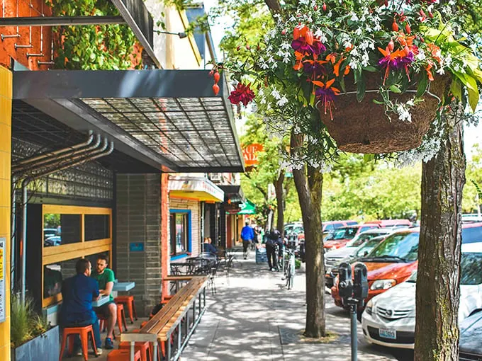 Sidewalk dining under hanging flower baskets – where the Pacific Northwest's famously good weather isn't just a myth, it's lunch policy.