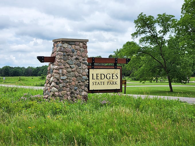 The entrance to adventure doesn't need flashing lights. This sturdy stone marker has welcomed generations of nature lovers to Iowa's geological masterpiece.
