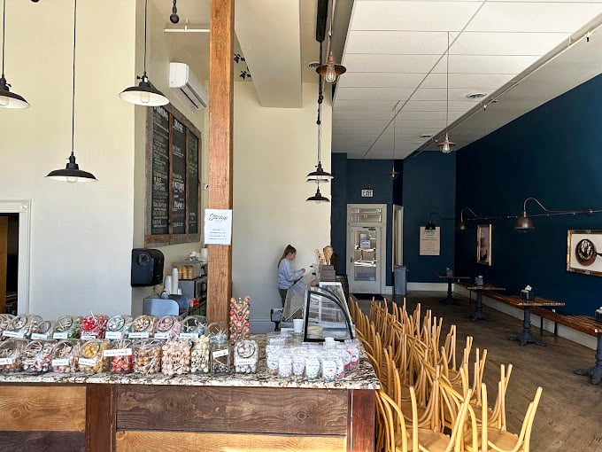 Rustic meets refined in this airy space where wooden beams, navy walls, and pendant lighting create the perfect backdrop for dessert euphoria.