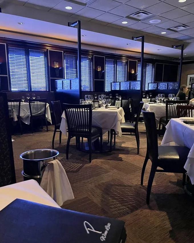The dining room whispers "special occasion" without shouting it—where crisp white tablecloths meet warm lighting in a space that makes Tuesday feel like Saturday.