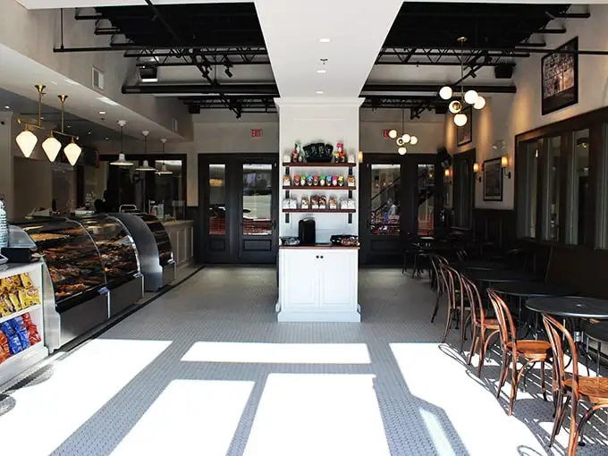 Step inside to classic deli charm—where the black and white tile floor meets modern lighting, and display cases promise delicious decisions ahead.