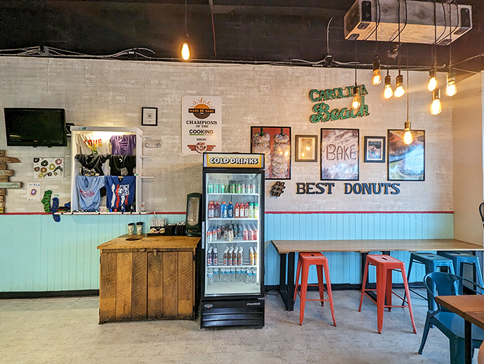 Inside, beach vibes meet donut paradise with turquoise wainscoting and exposed Edison bulbs. The "BEST DONUTS" sign isn't bragging—it's just stating facts.