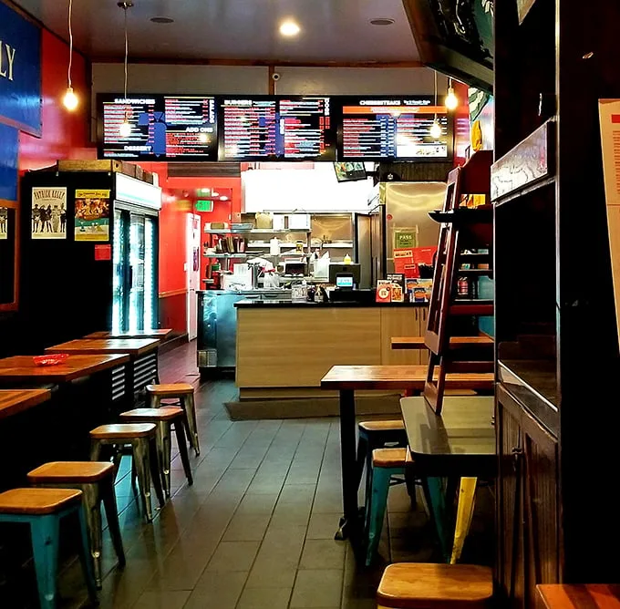 Inside Jake's, the vibrant red walls and no-nonsense seating announce that you're here for serious sandwich business, not Instagram aesthetics.