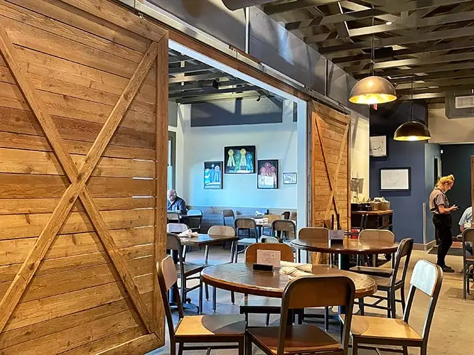 Rustic barn doors frame a dining space where barbecue dreams come true—warm wood tones and industrial touches creating the perfect smoke-infused sanctuary.