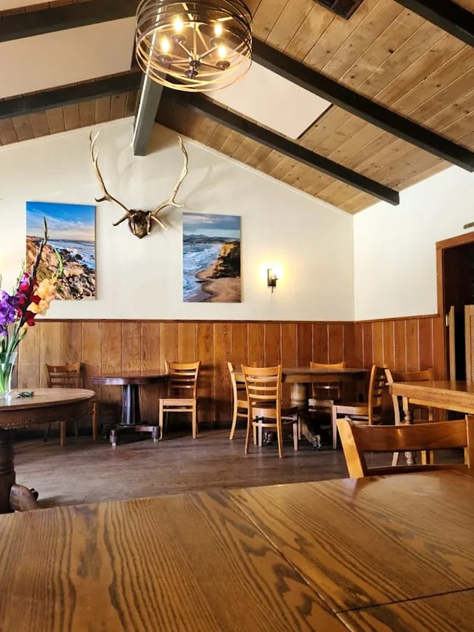 Rustic wood paneling, antler mounts, and coastal photographs—this dining room doesn't need trendy design elements when it has decades of genuine character.