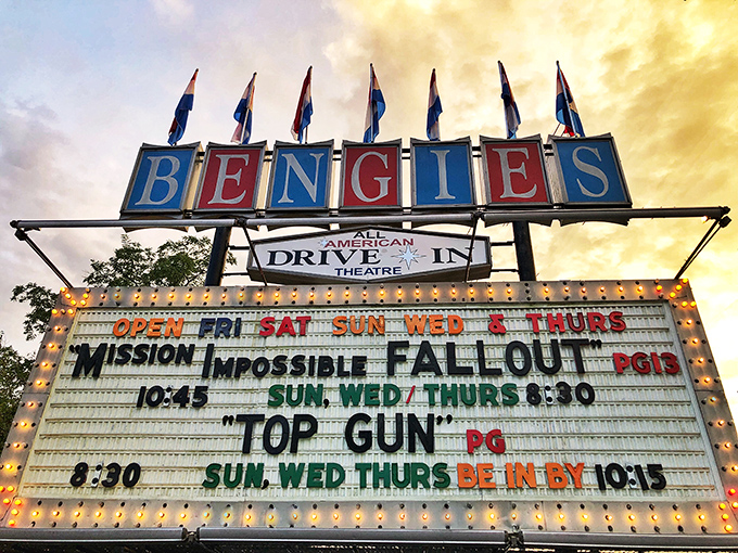 Dusk transforms the illuminated marquee into a beacon of nostalgia, announcing tonight's cinematic treasures like a town crier from Hollywood's heyday.